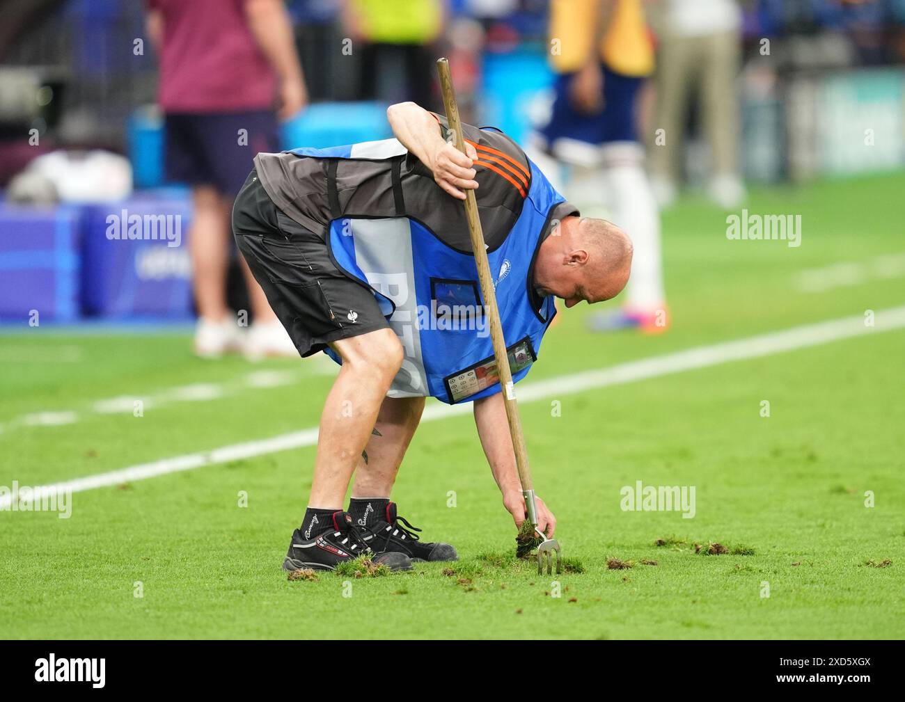 Ground staff tend to divots in the turf at half-time during the UEFA ...