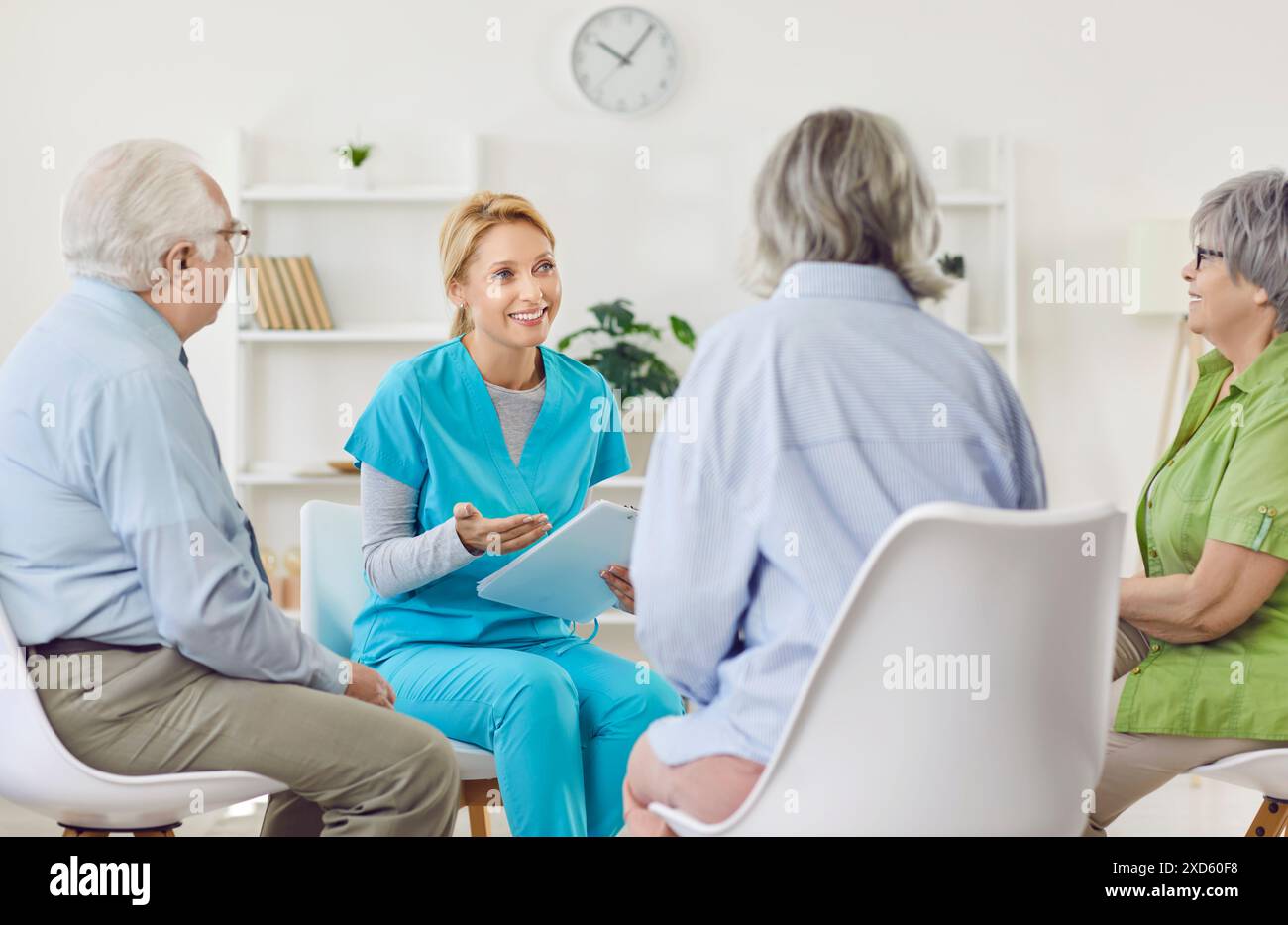 Group of senior people at retirement home having meeting with friendly ...