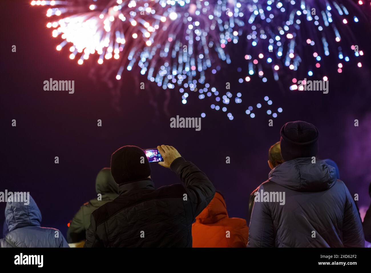 people watching fireworks in a night sky, rear view Stock Photo - Alamy