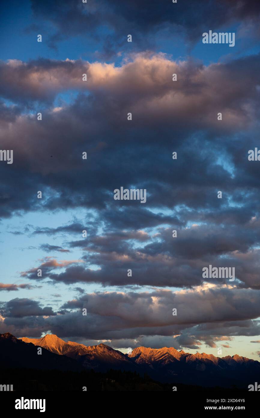 A sunrise illuminates the clouds and the Purcell Mountains over Lake ...