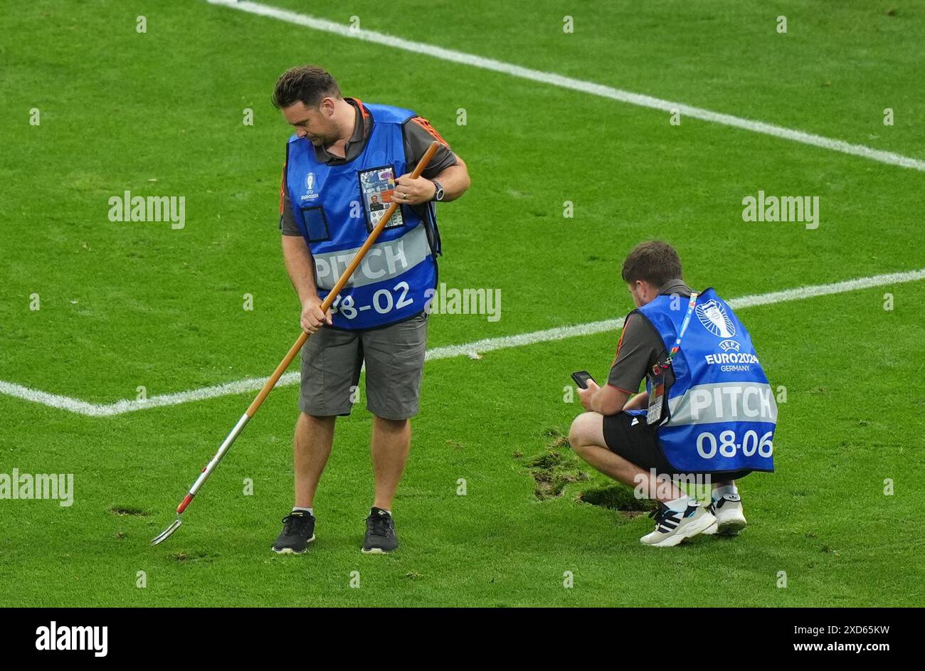 Ground staff tend to divots in the turf after the UEFA Euro 2024 match ...