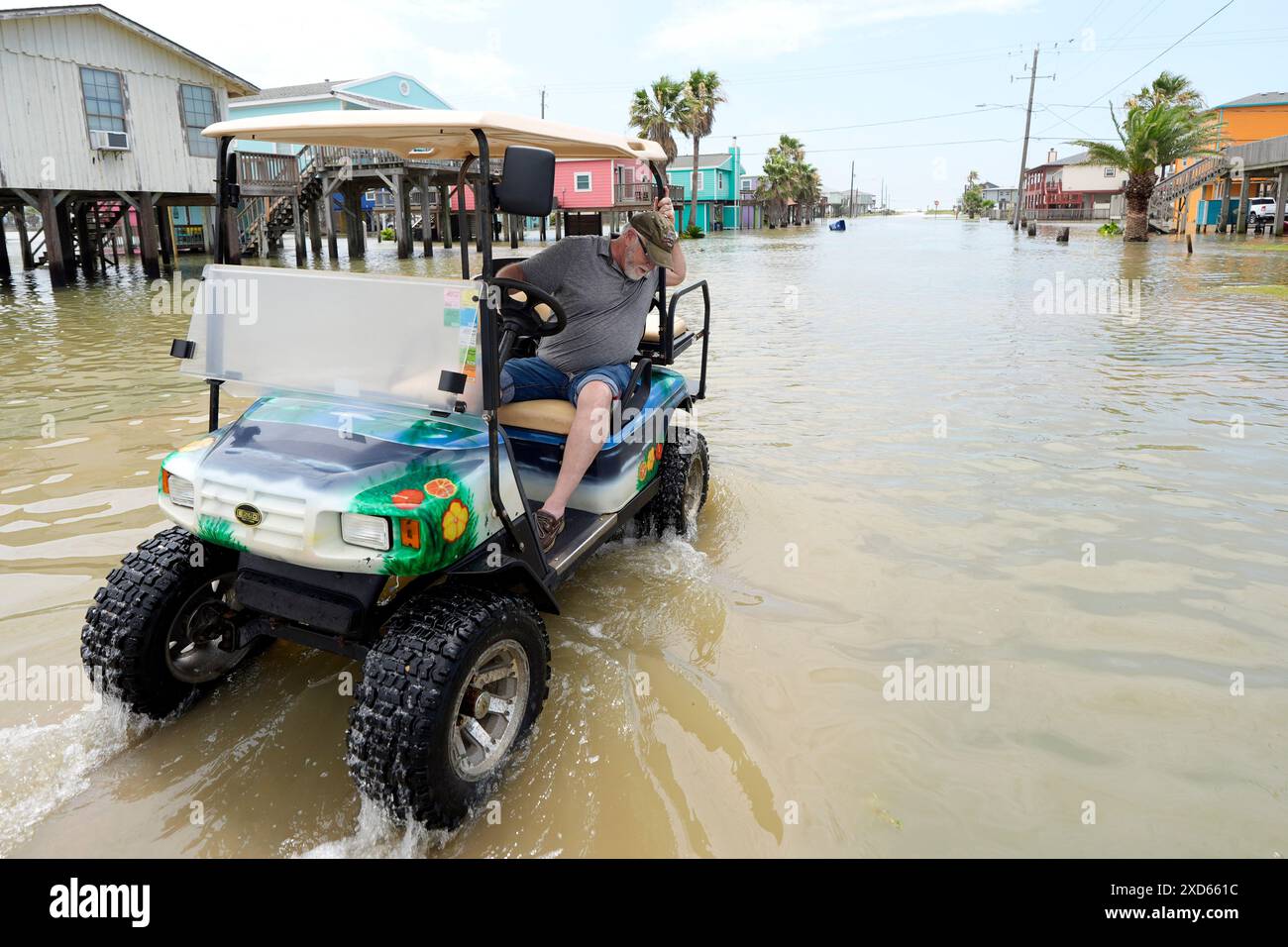 Jamie Baumgart drives his golf cart through water from a tidal surge in ...