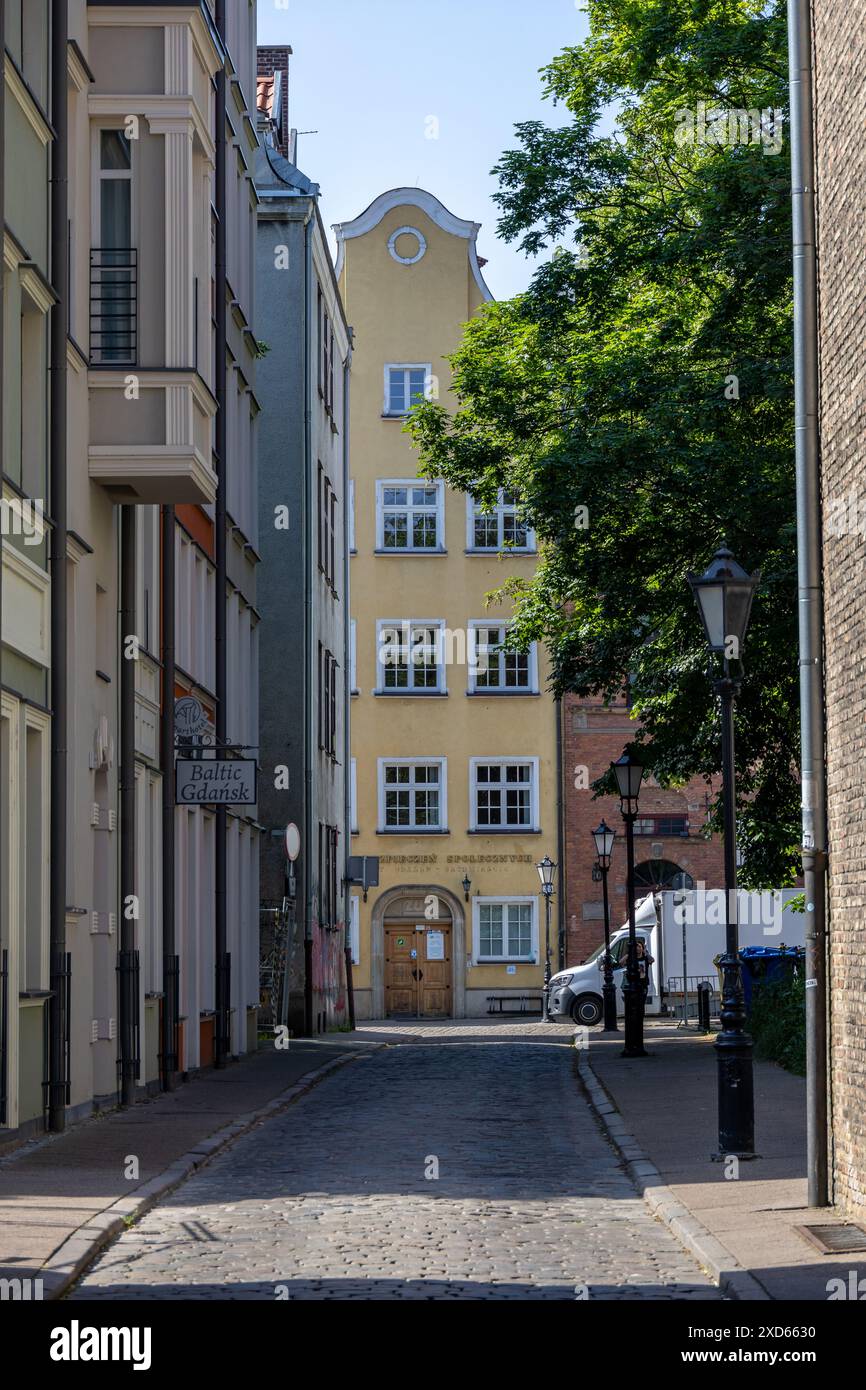 A quiet alley in Gdansk leading to a charming yellow building ...