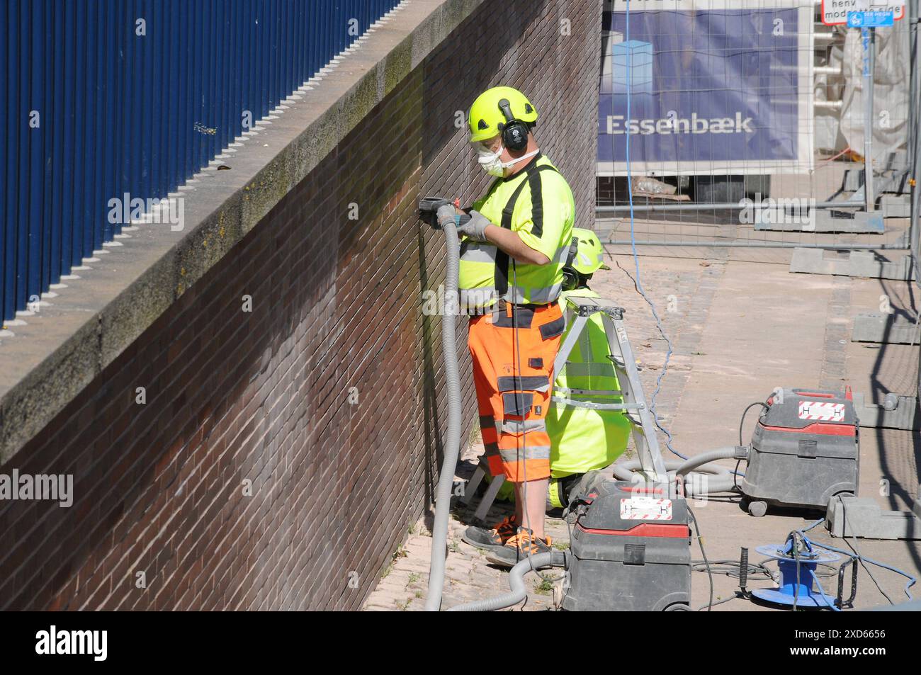 Copenhagen/ Denmark/20 JUNE 2024/ Worker cleaning of washing brick wall ...