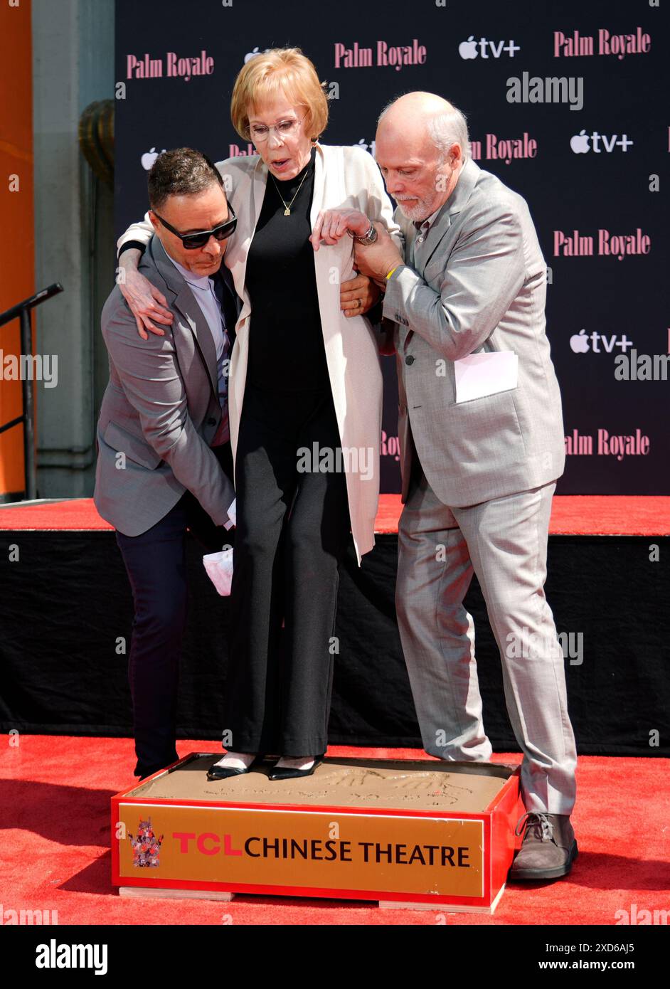 Comedian Carol Burnett, center, is helped by security guard Guy Friedman, left, and her husband ...