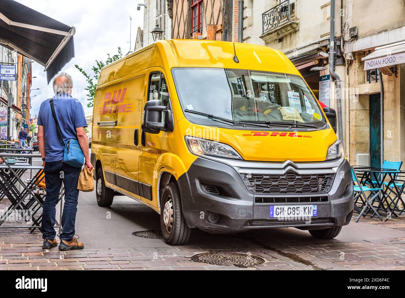 Citroen DHL delivery van driving slowly through a narrow street in old ...