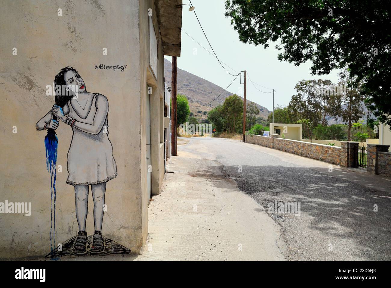 Street scene - street art on the side of a building of a woman washing ...