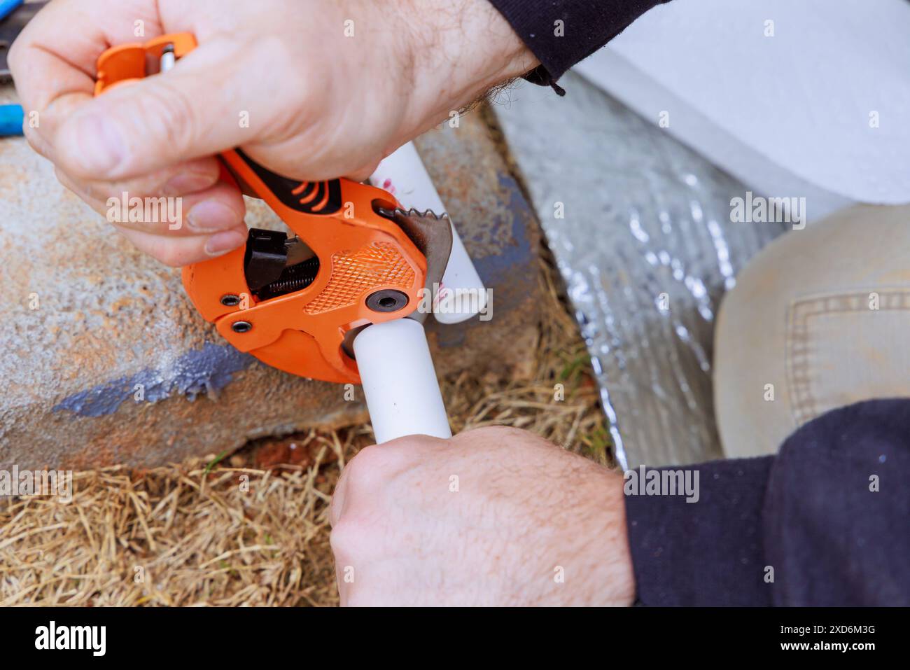 When installing water pipe, plumber cuts plastic PVC pipe with special ...