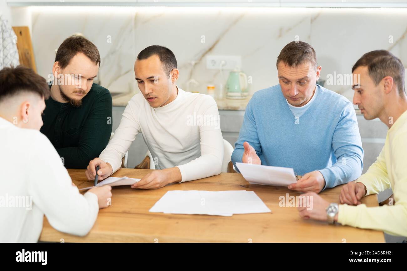 Group of men supporting troubled friend reading legal notice Stock ...