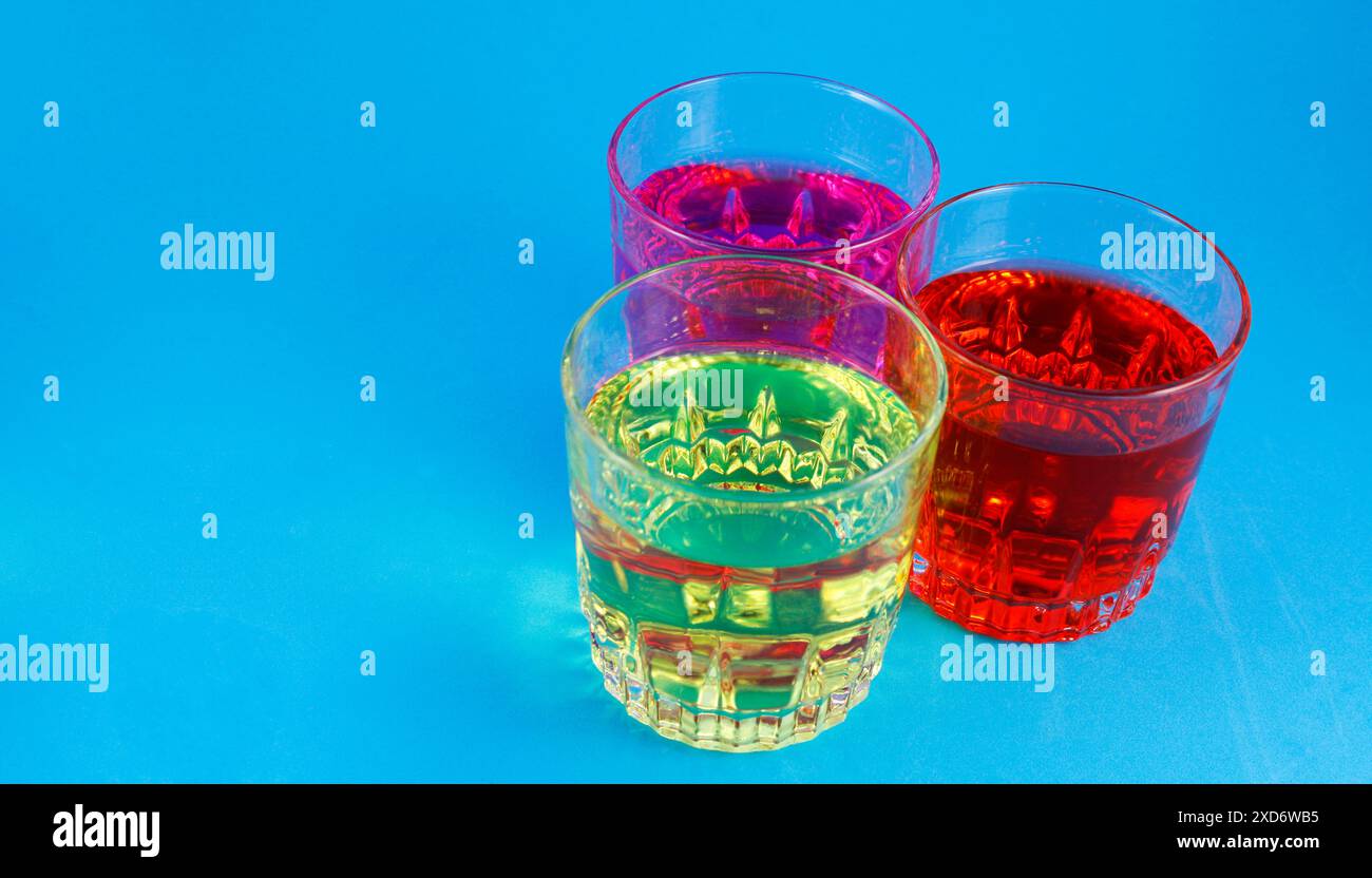 Three transparent glasses containing water with artificial colors Stock ...