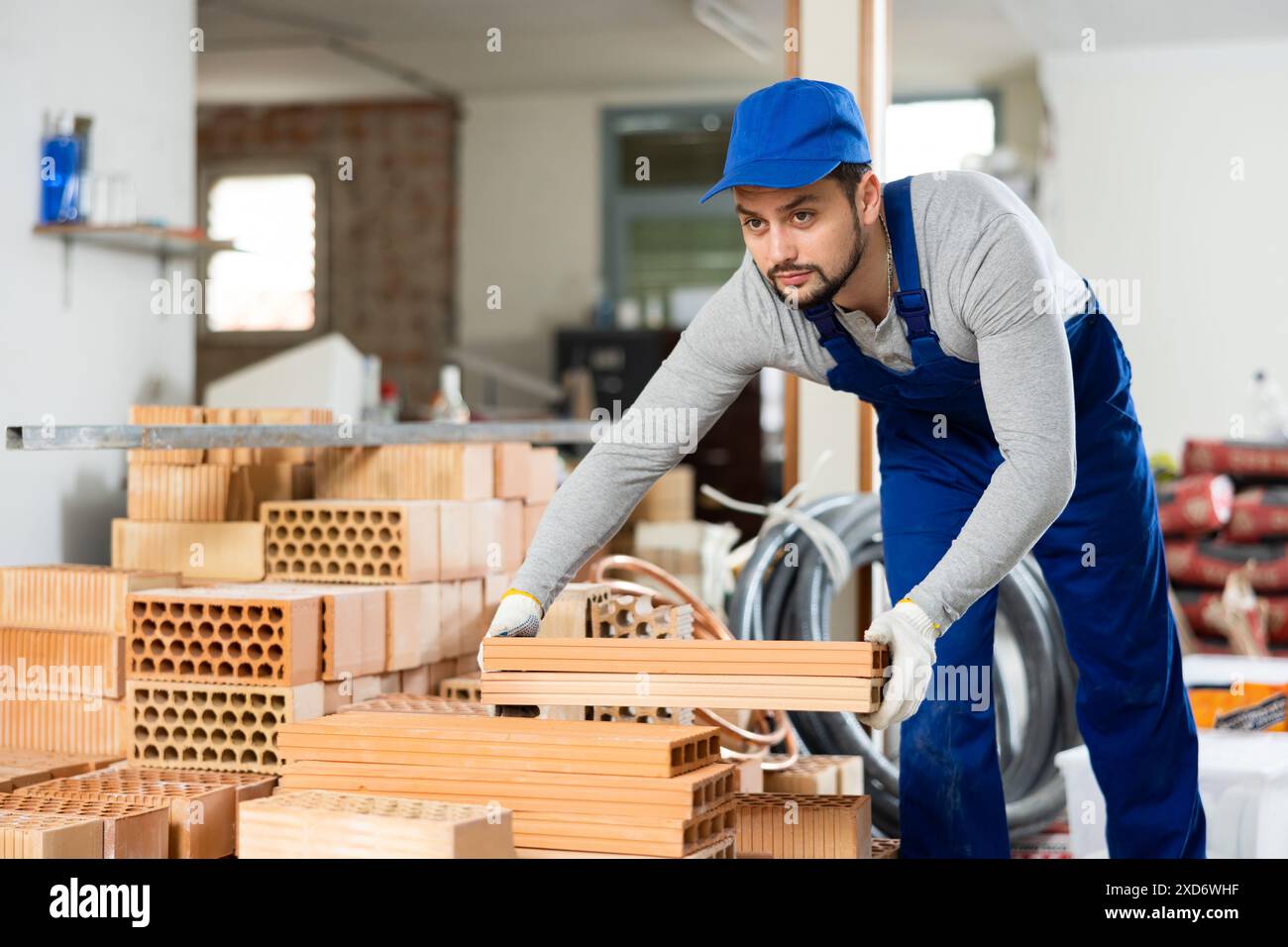 Professional builder puts construction material Stock Photo - Alamy