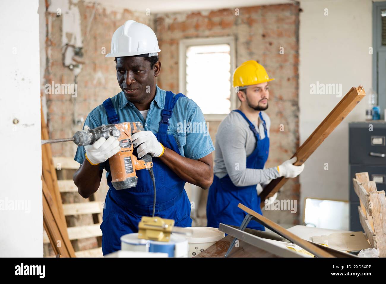 Two builders performing major repairs in the house Stock Photo - Alamy