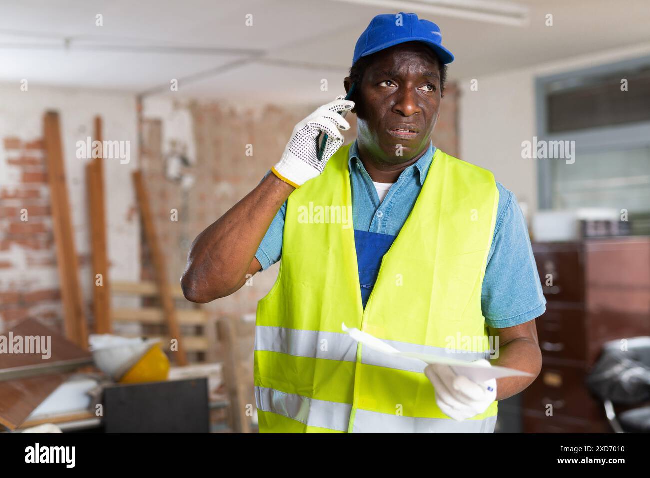 African american contractor with papers talking on phone at ...