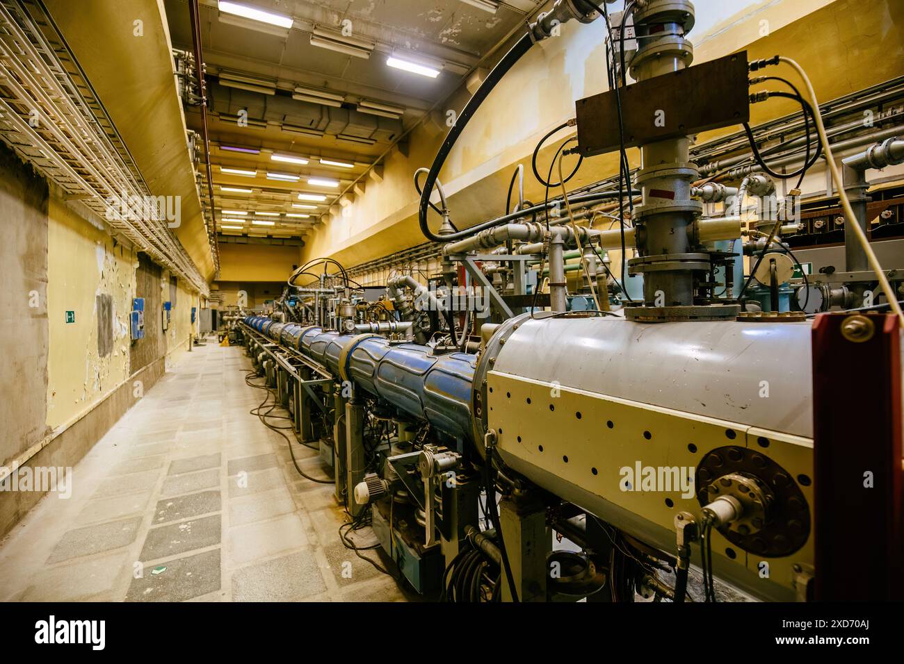 Large metal tube of particle accelerator with connected pipes. Old ...