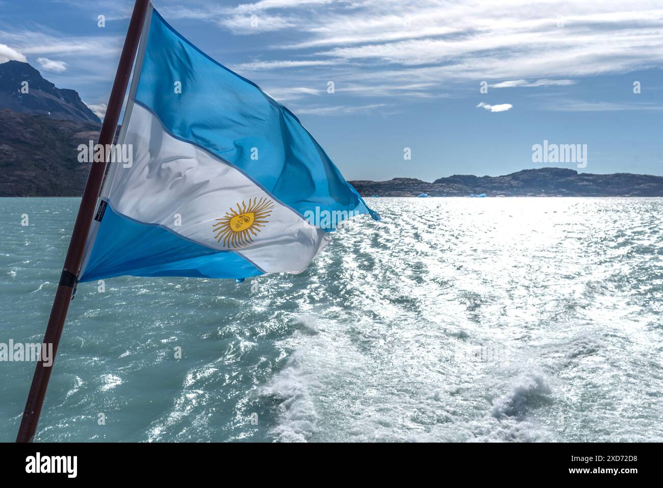 A blue and white Argentine flag with the sun in the middle flies on a ...