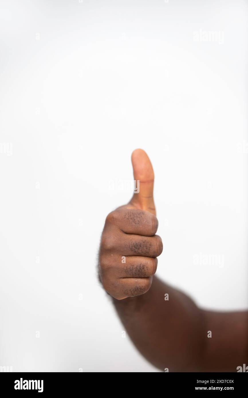 black Hand making thumbs up sign gesture over white background, frontal ...