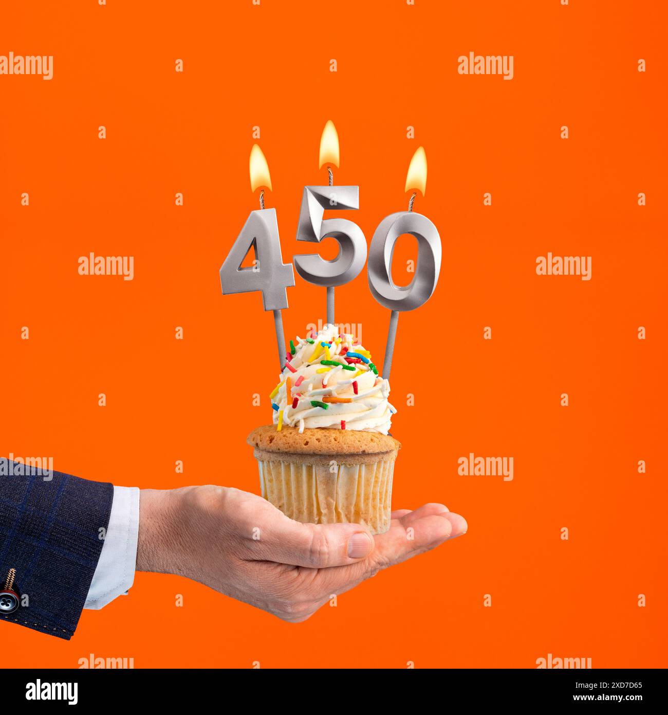 The hand that delivers cupcake with the number 450 candle - Birthday on ...