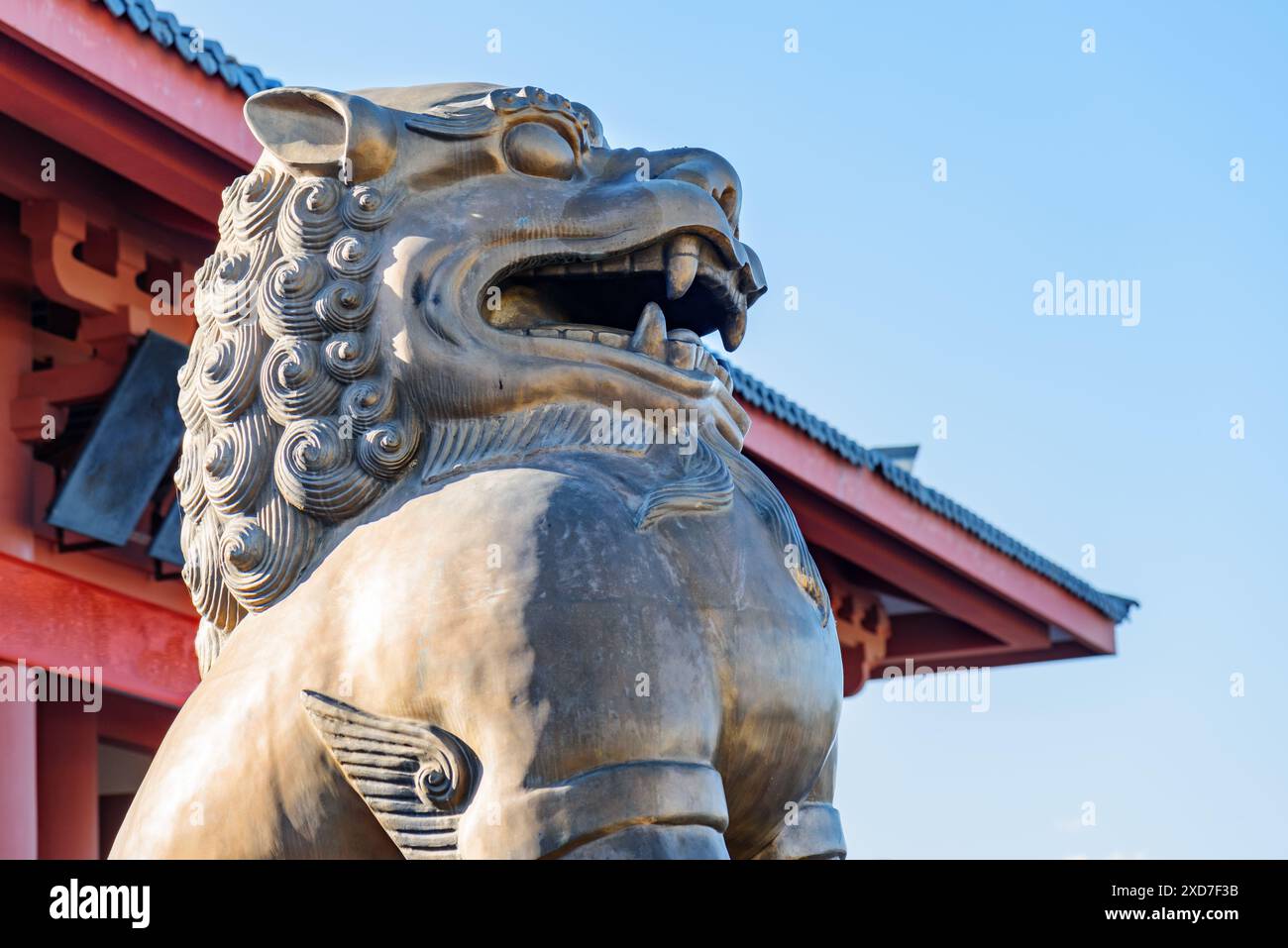 Amazing statue of mystical Chinese guardian lion on red roof background ...
