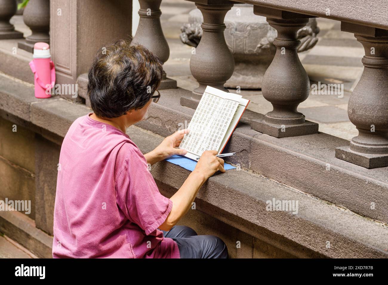 Taipei, Taiwan - April 22, 2019: Elderly Chinese woman reading a book ...