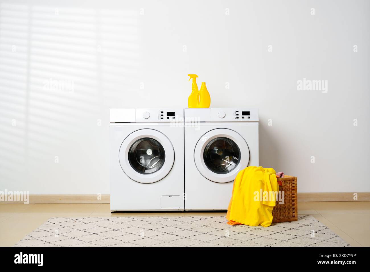 White Washing Machine With Yellow Cleaning Supplies in a Laundry Room ...