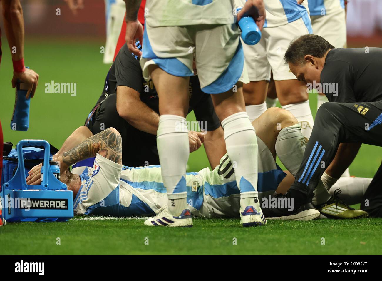 Argentina's forward Lionel Messi (bottom) gestures in pain and is ...