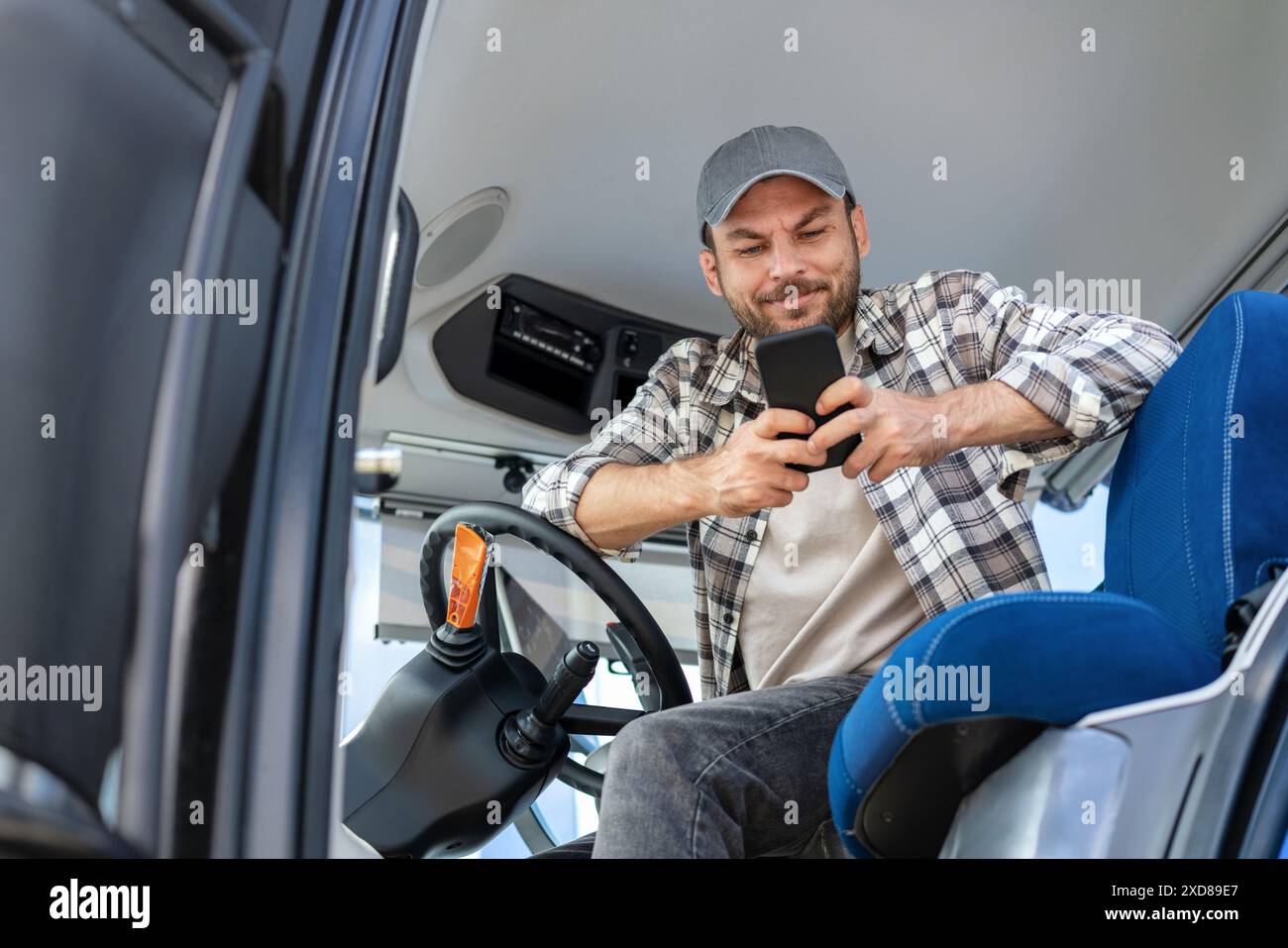 Man farm tractor driver sits in cabin and using his mobile phone Stock ...