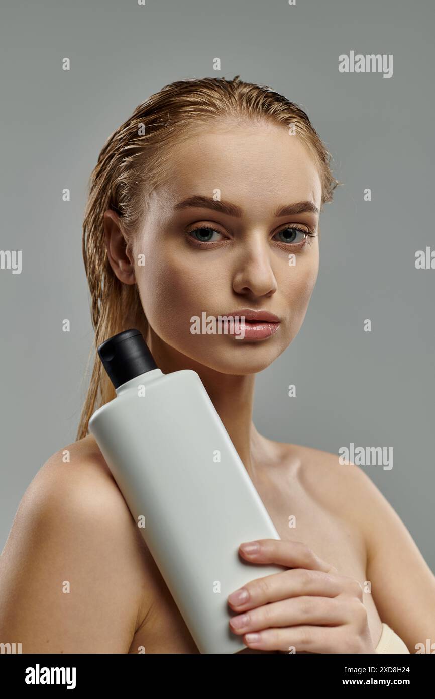A young woman showcases her hair care routine holding a bottle of ...
