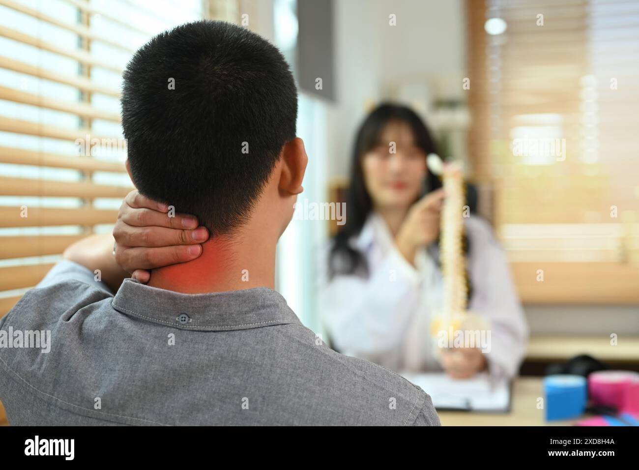 Male patient touching painful neck near explaining to physiotherapist ...