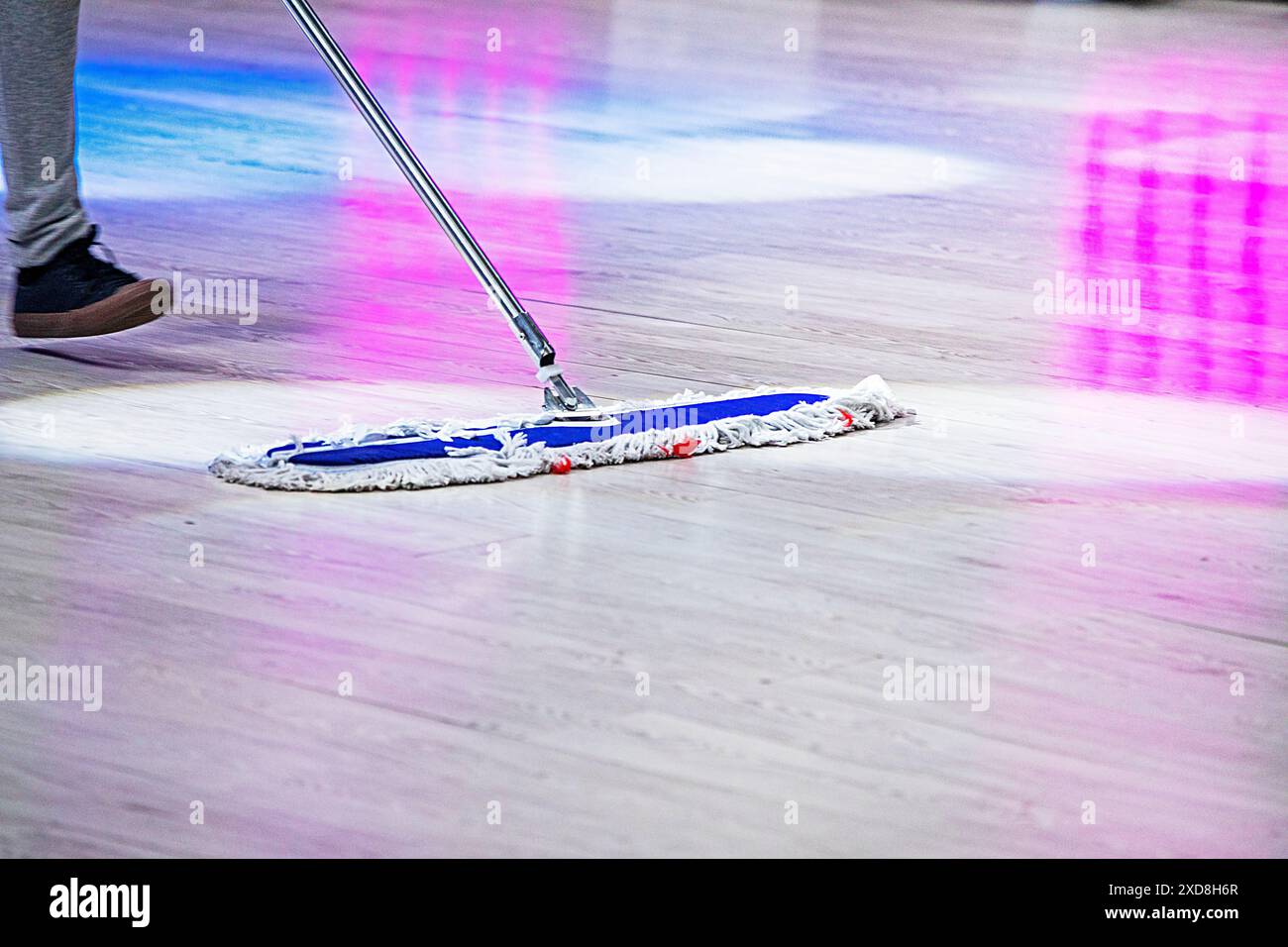 wipe the parquet floor with a mop and rag before a dance competition ...