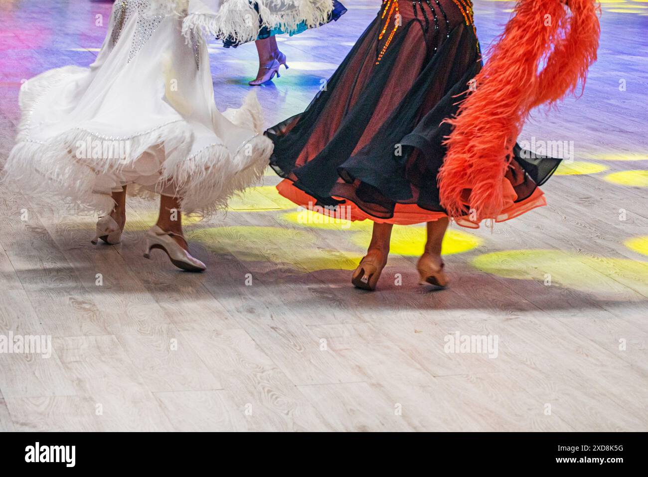 dance on high heels dance in a lush crowd in multi-colored red dresses ...