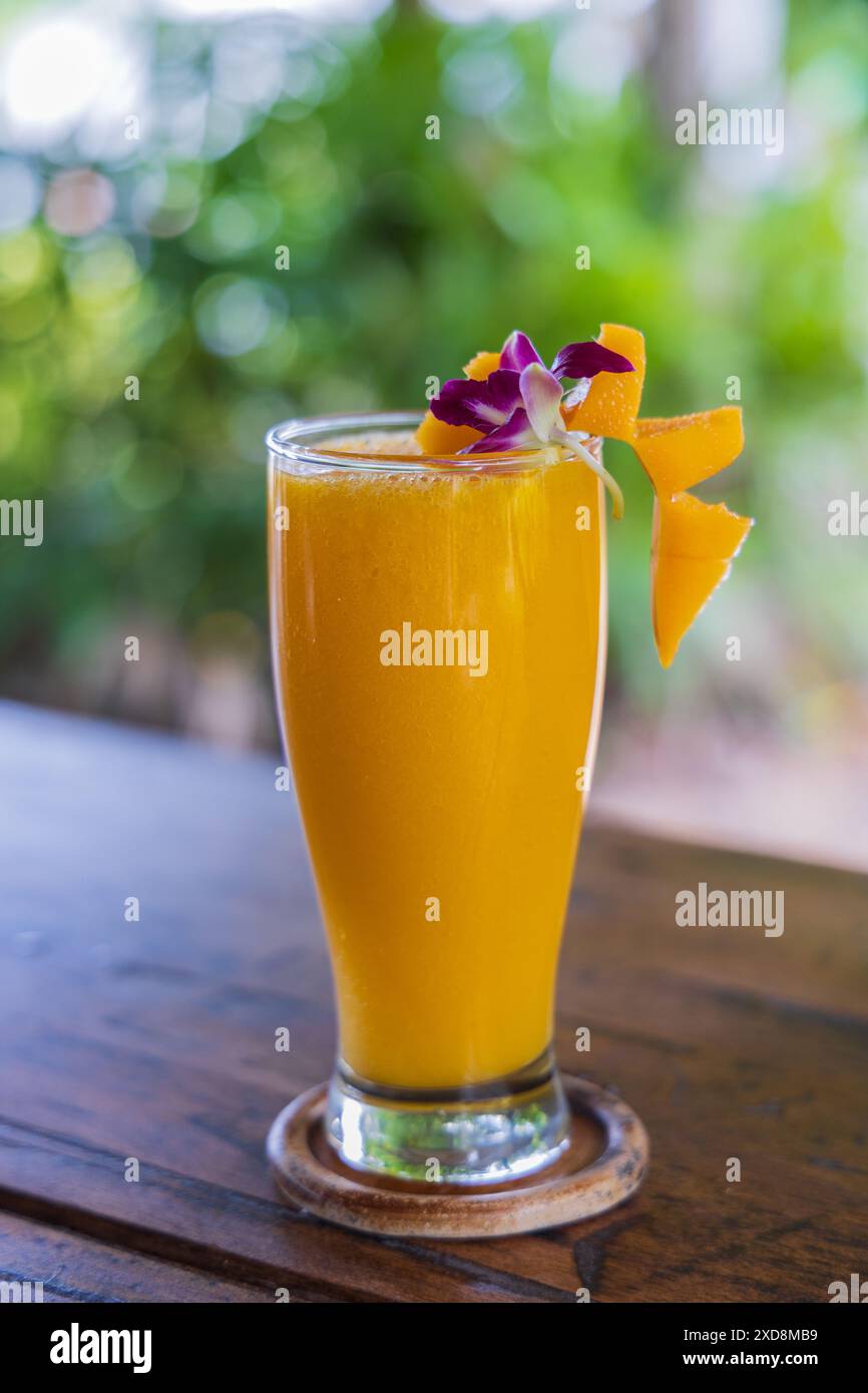 Mango smoothie in a glass with fresh mango. Mango refreshing shake ...