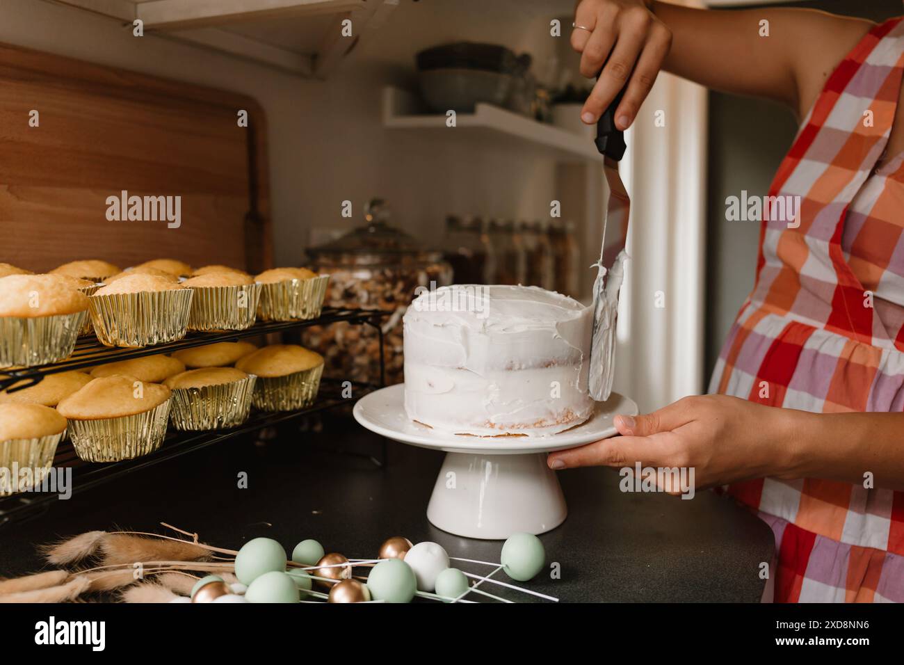 A woman decorating a birthday cake with white frosting Stock Photo - Alamy