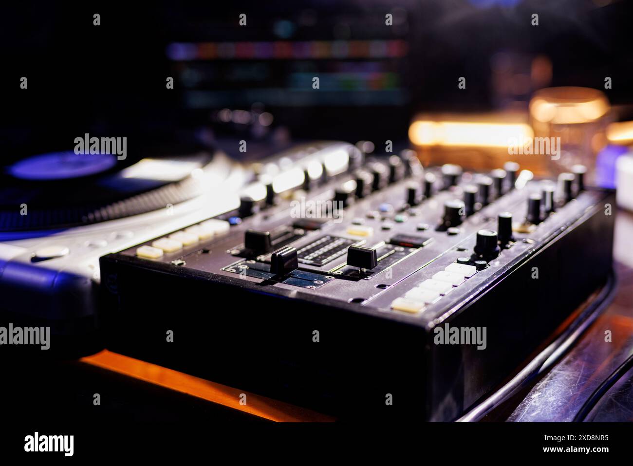 A close-up view of a professional DJ mixing console with various knobs ...