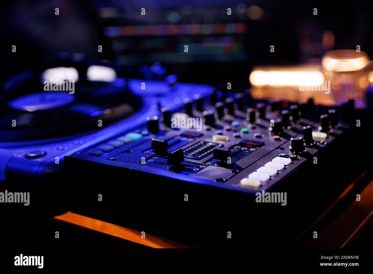 A close-up view of a professional DJ mixing console with various knobs ...