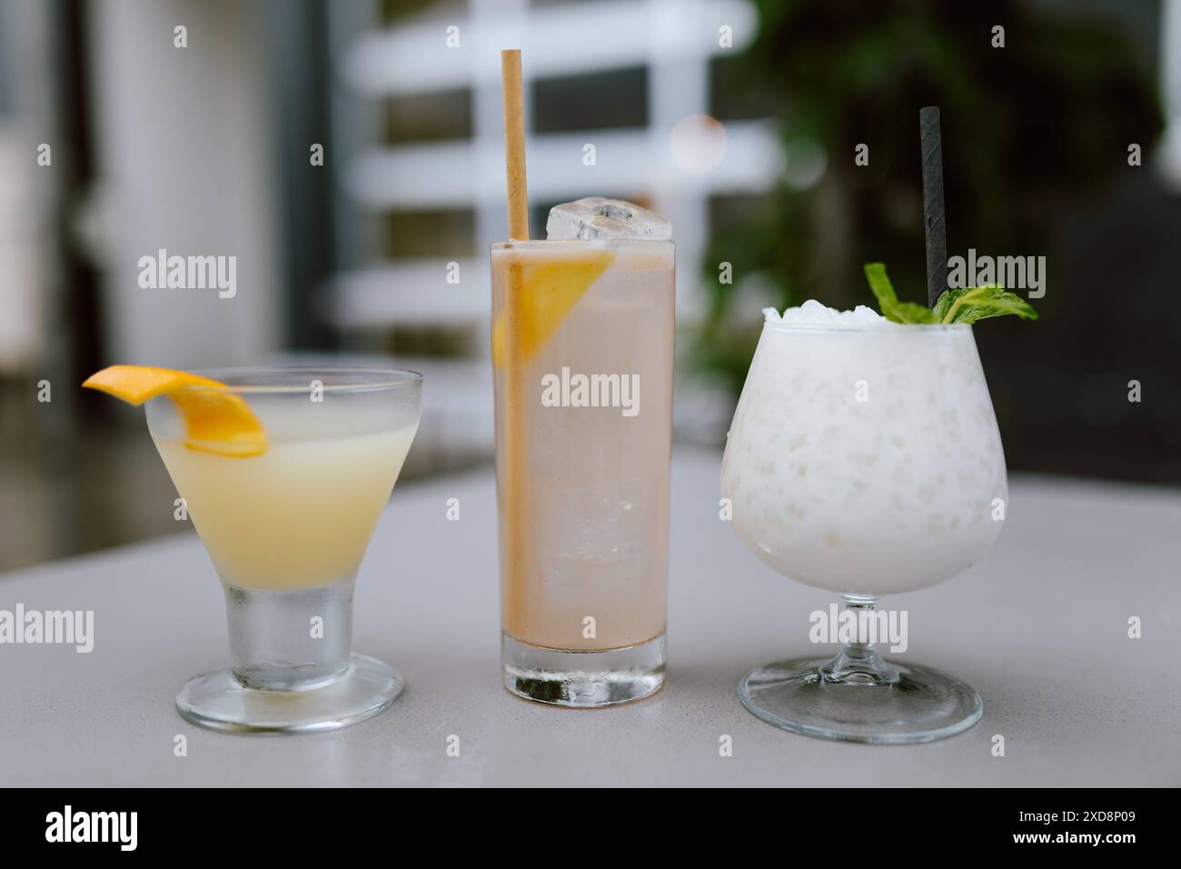 Three assorted cocktails on a table with different garnishes Stock ...