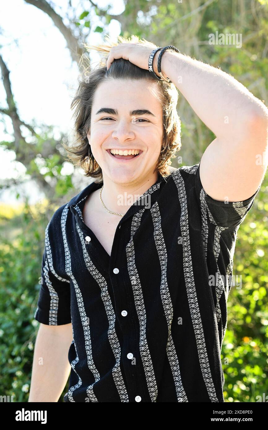 Young man with a big smile, running his hand through his hair i Stock ...