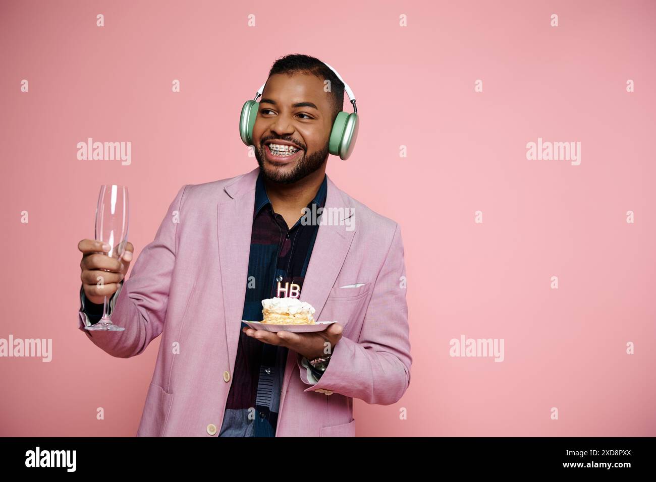 Young African American man in braces joyfully holds birthday cake while ...