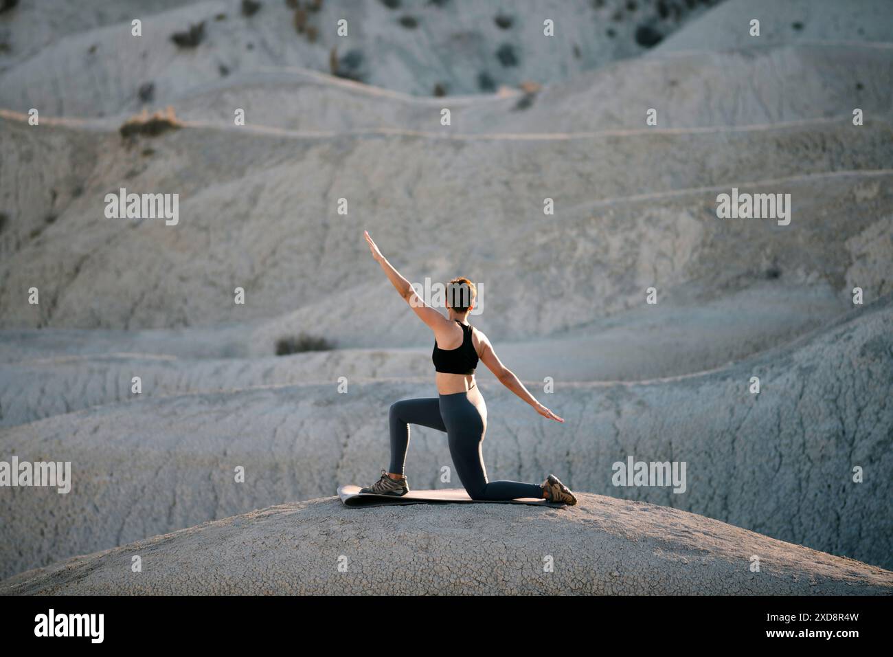 Woman doing warrior asana pose in the desert Stock Photo - Alamy