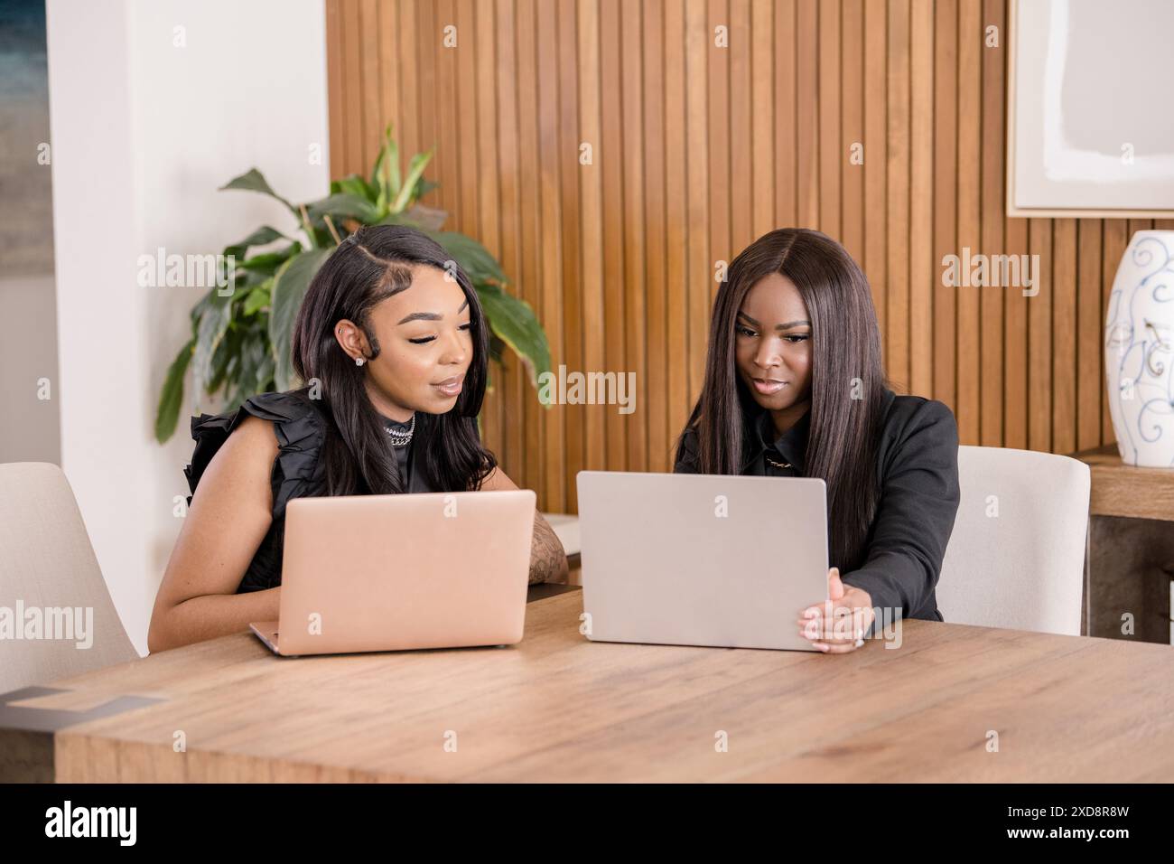 Serious business women working at a large wood desk on their lap Stock ...