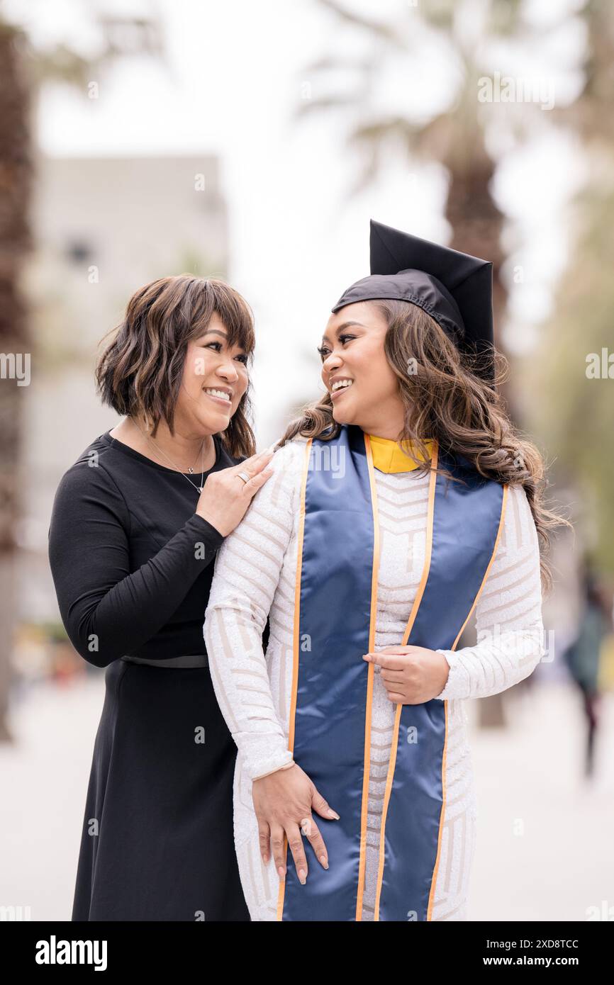 Mother of graduate looking into daughters eyes smiling Stock Photo - Alamy