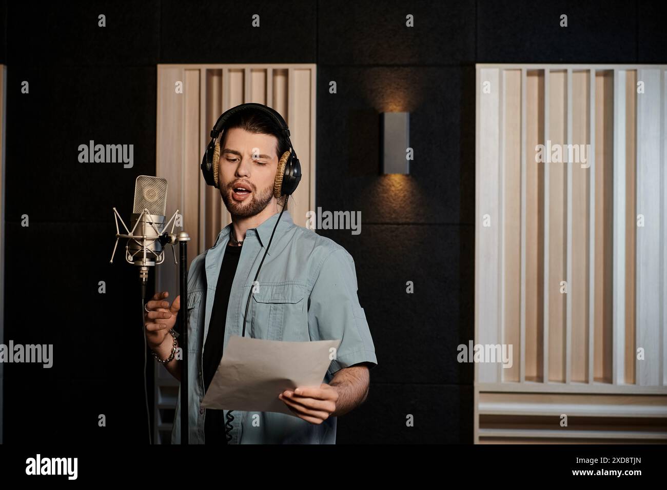 A man passionately sings in a recording studio during a music band ...