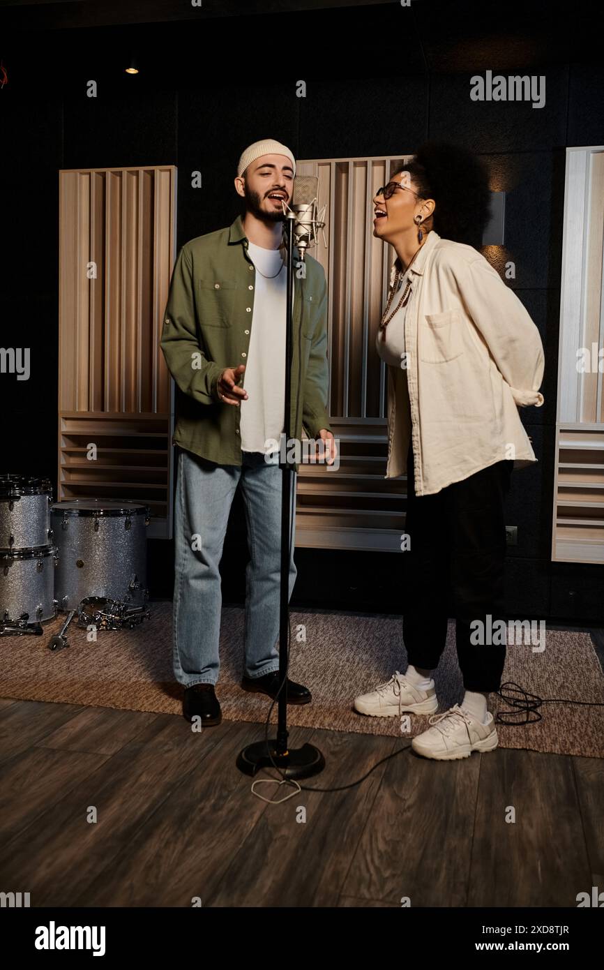 Two singers stand by the microphone in a recording studio, preparing ...