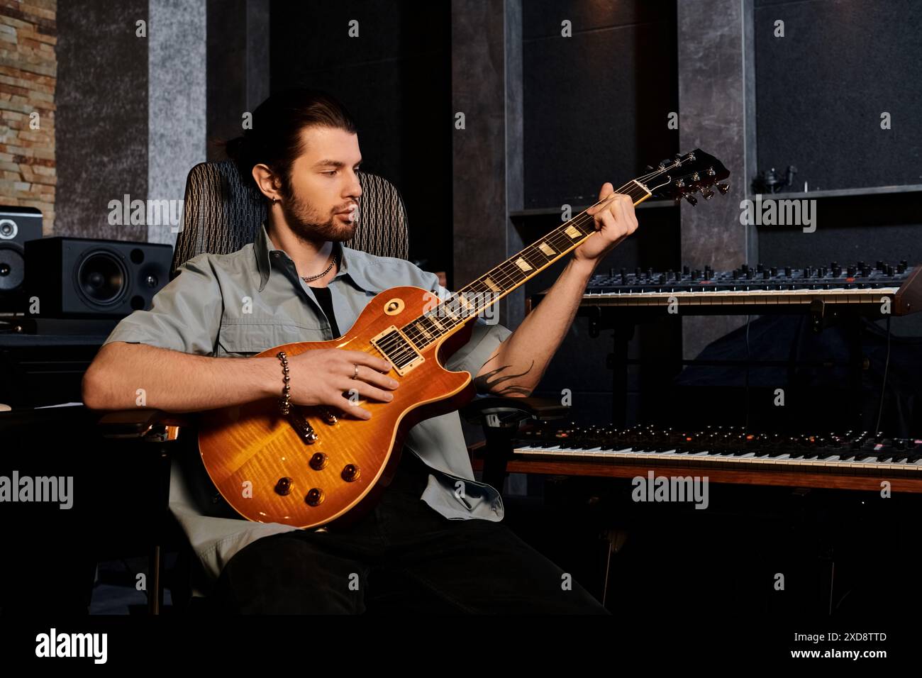 A skilled man playing an electric guitar in a recording studio as part ...