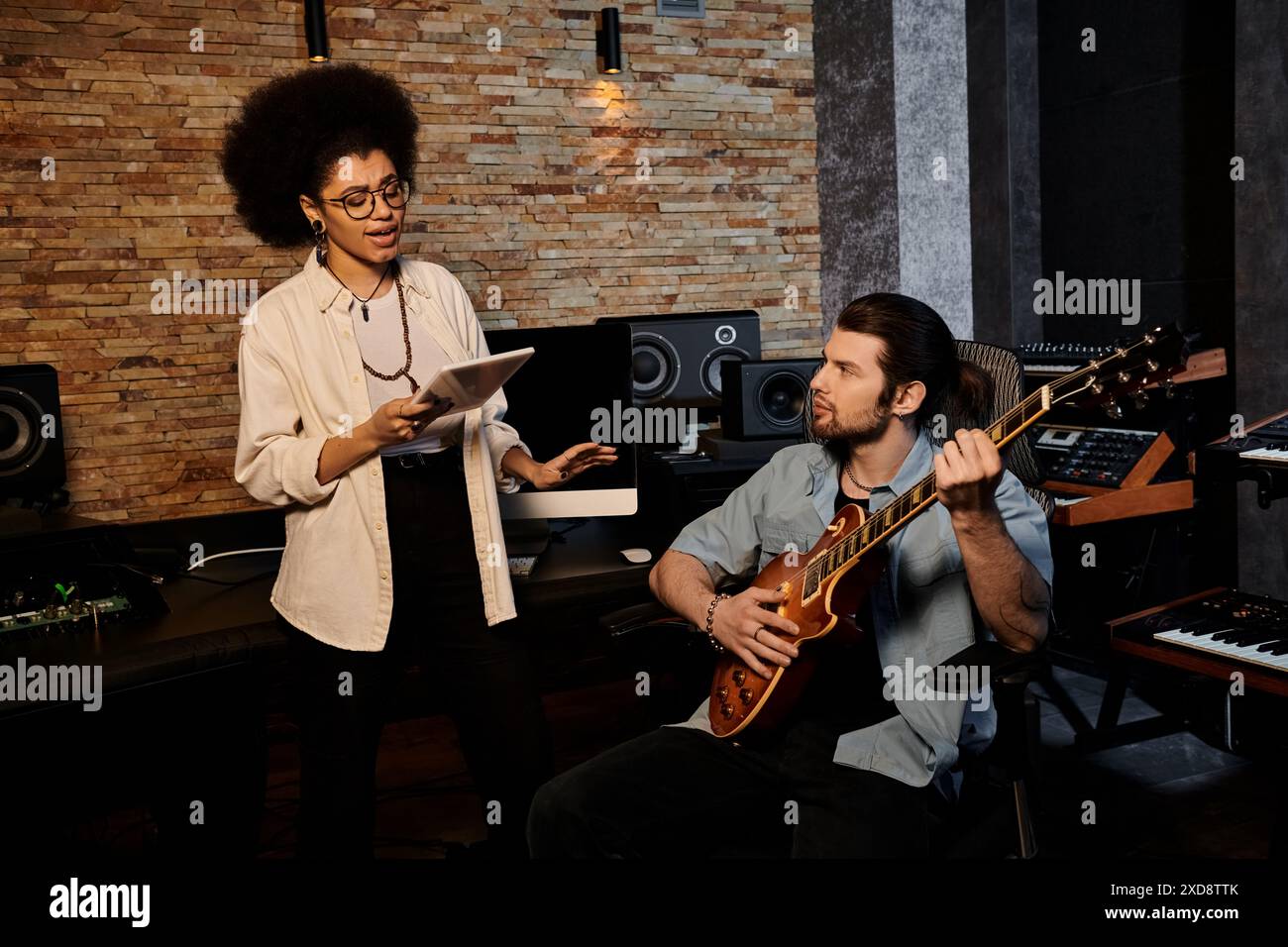Woman and man collaborate in music band rehearsal within recording ...