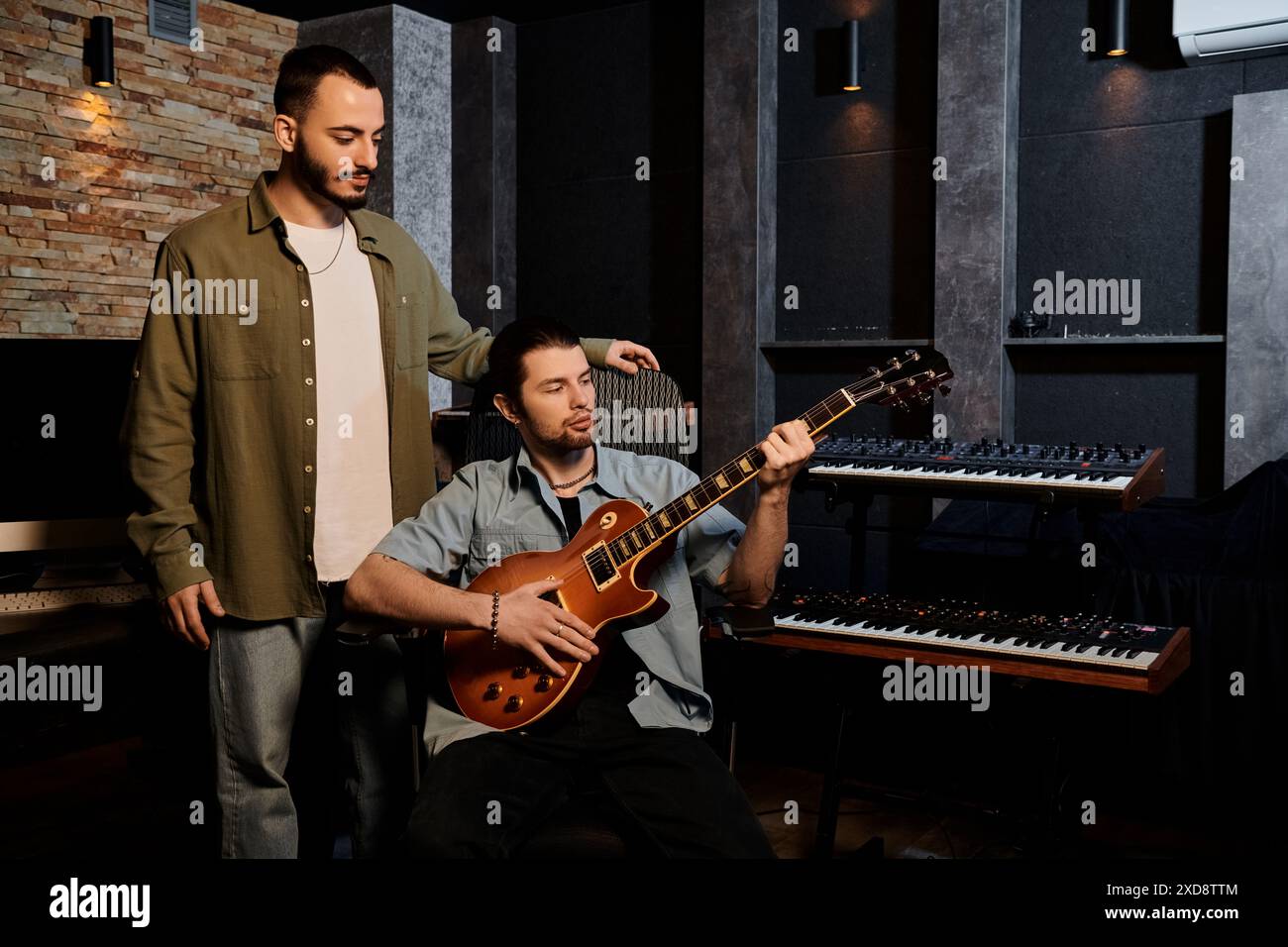 Two men stand side by side, immersed in a music band rehearsal in a ...