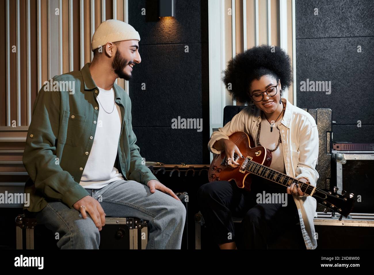 A man and a woman play guitar in a recording studio, creating music ...