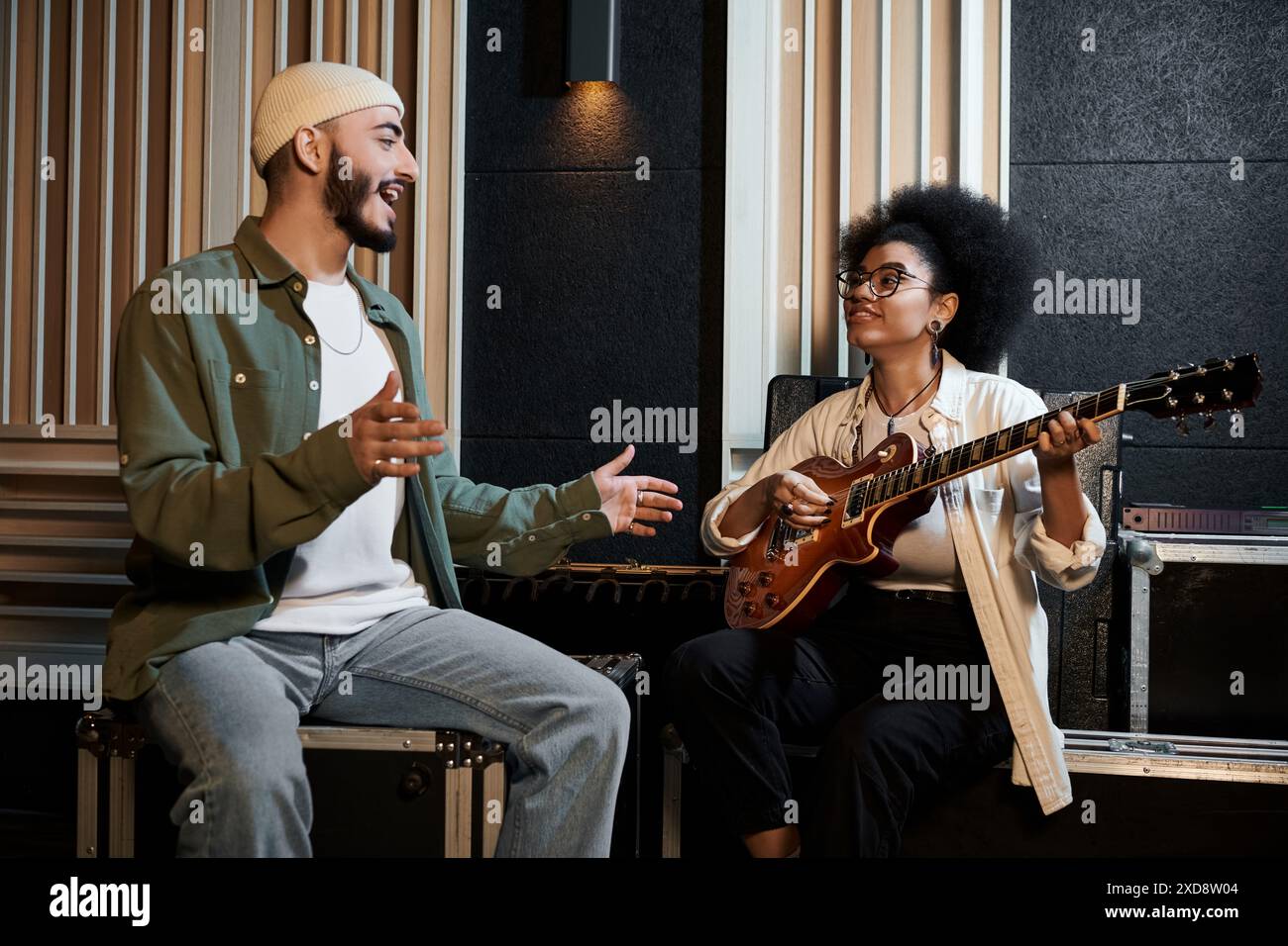 A man and woman passionately play guitars in a recording studio ...