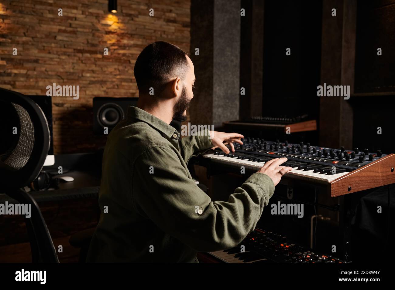 A man creating music on an electronic keyboard, immersed in a recording ...