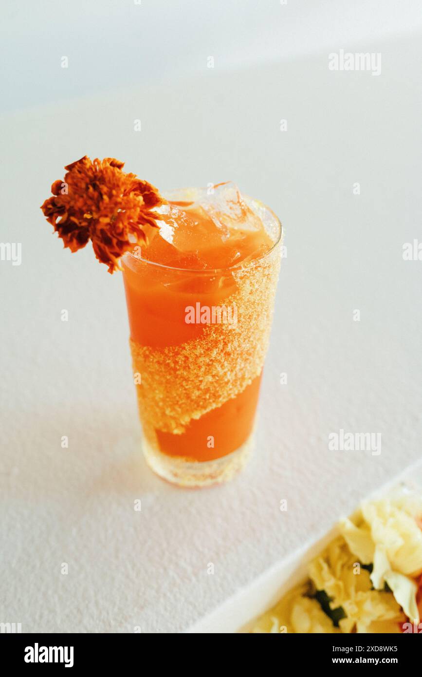 Orange cocktail with floral garnish Stock Photo - Alamy
