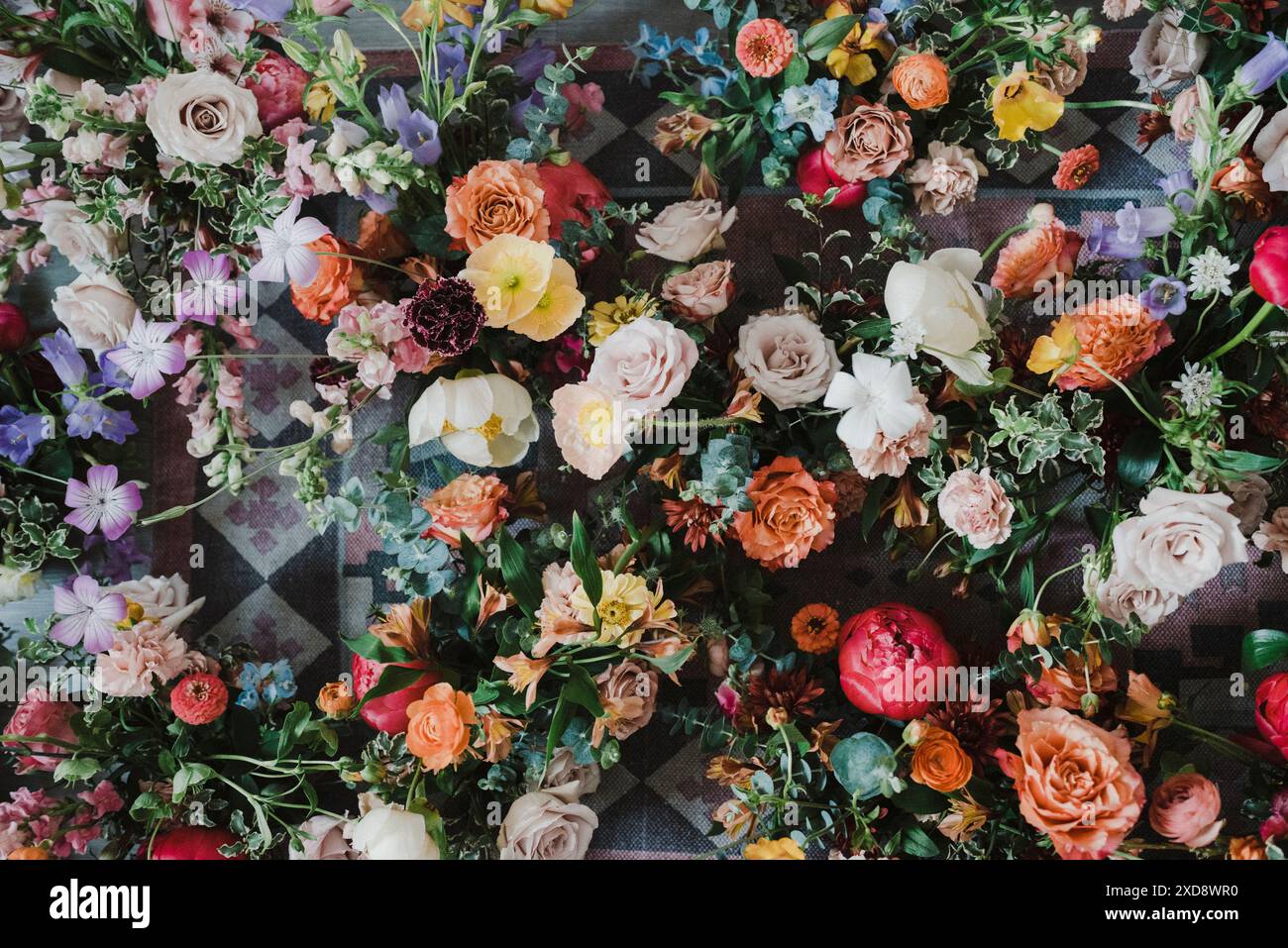 Overhead view of a vibrant floral arrangement on a patterned rug Stock ...